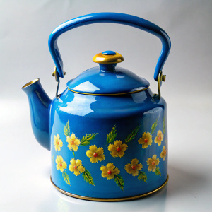 A blue kettle with yellow flowers painted on it isolated on background ...